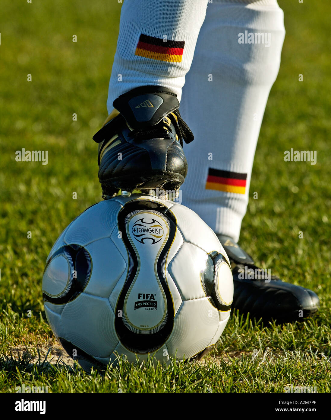the legs of a german national soccer player and the official ball of ...