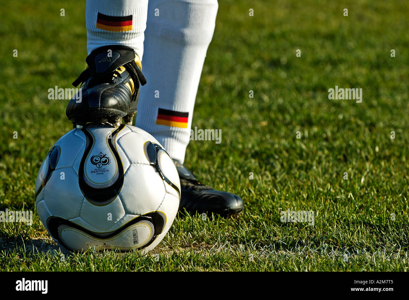 the legs of a german national soccer player and the official ball of ...