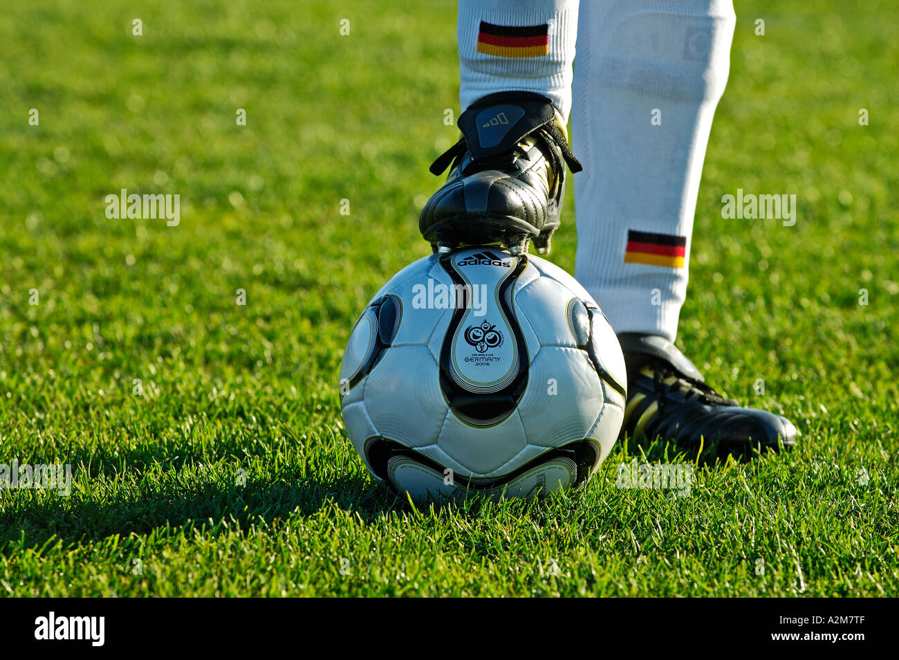 the legs of a german national soccer player and the official ball of ...