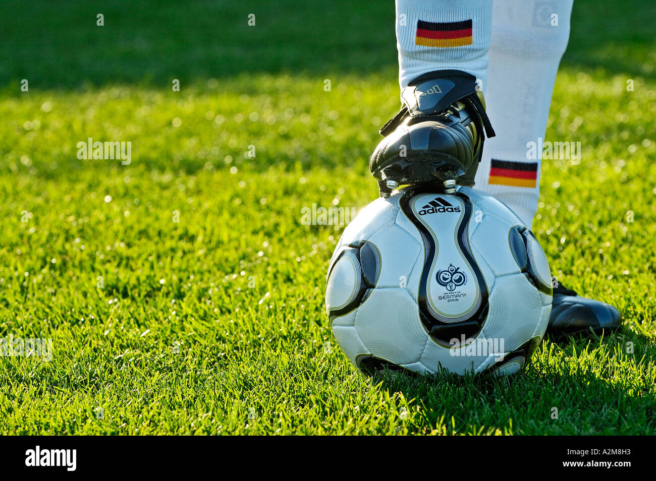 the legs of a german national soccer player and the official ball of ...