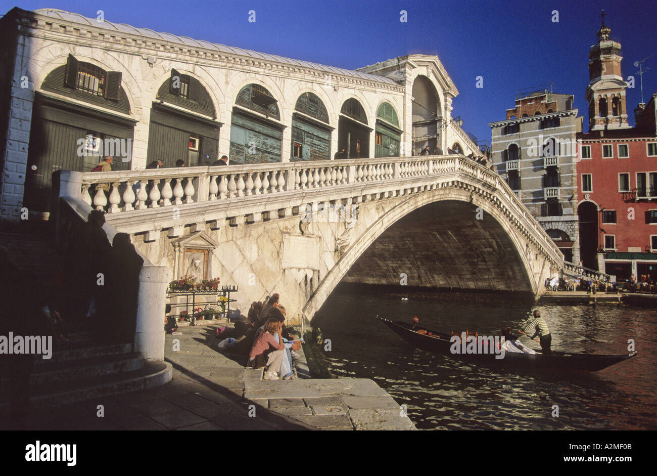 the rialto bridge with a gondola passing under neath Stock Photo - Alamy
