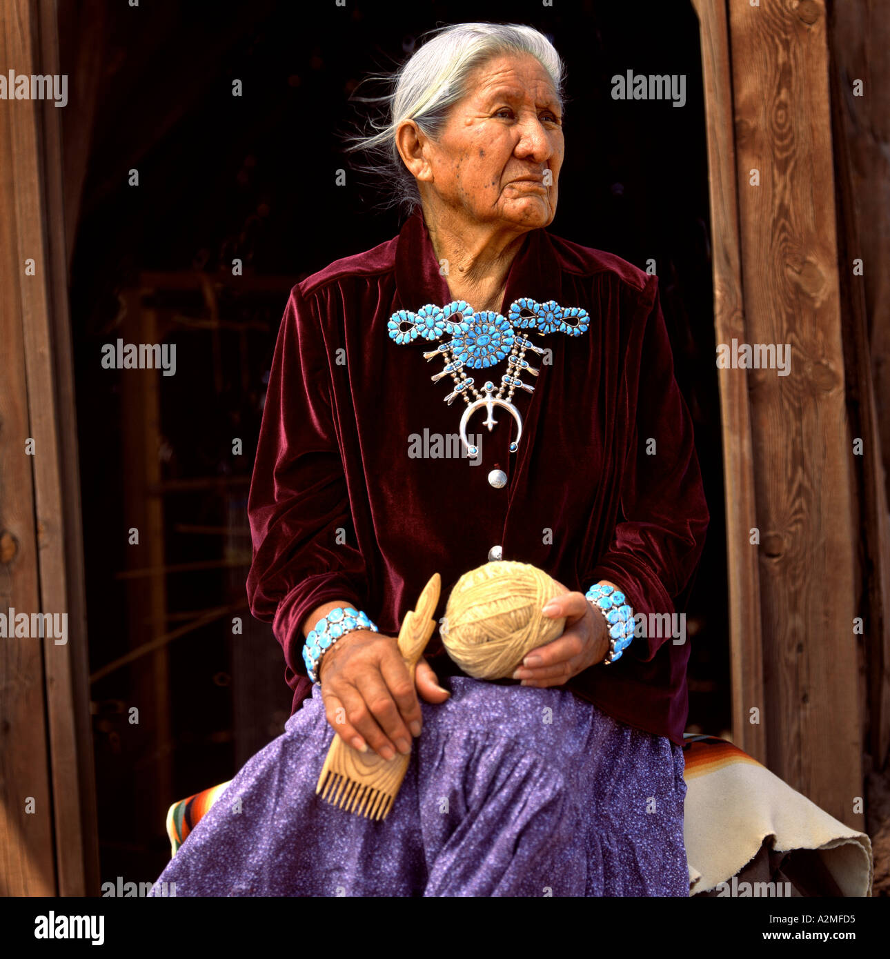 portrait of an old Navajo weaver in front of a traditional male hogan ...