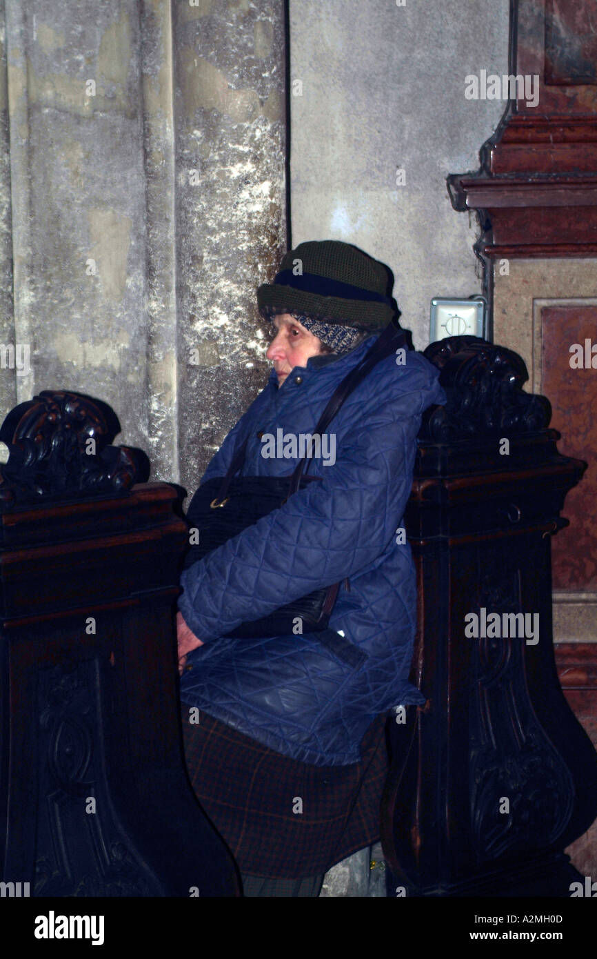 Homeless old woman sitting in the central Vienna church to keep warm ...