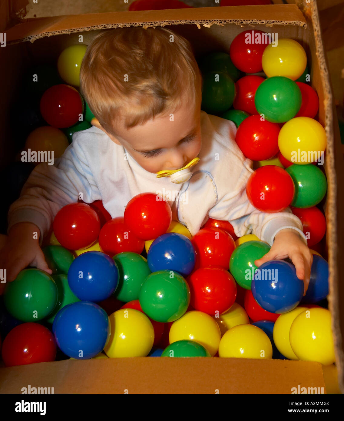 baby sitting in box with hundreds of colorful plastic balls Stock Photo ...