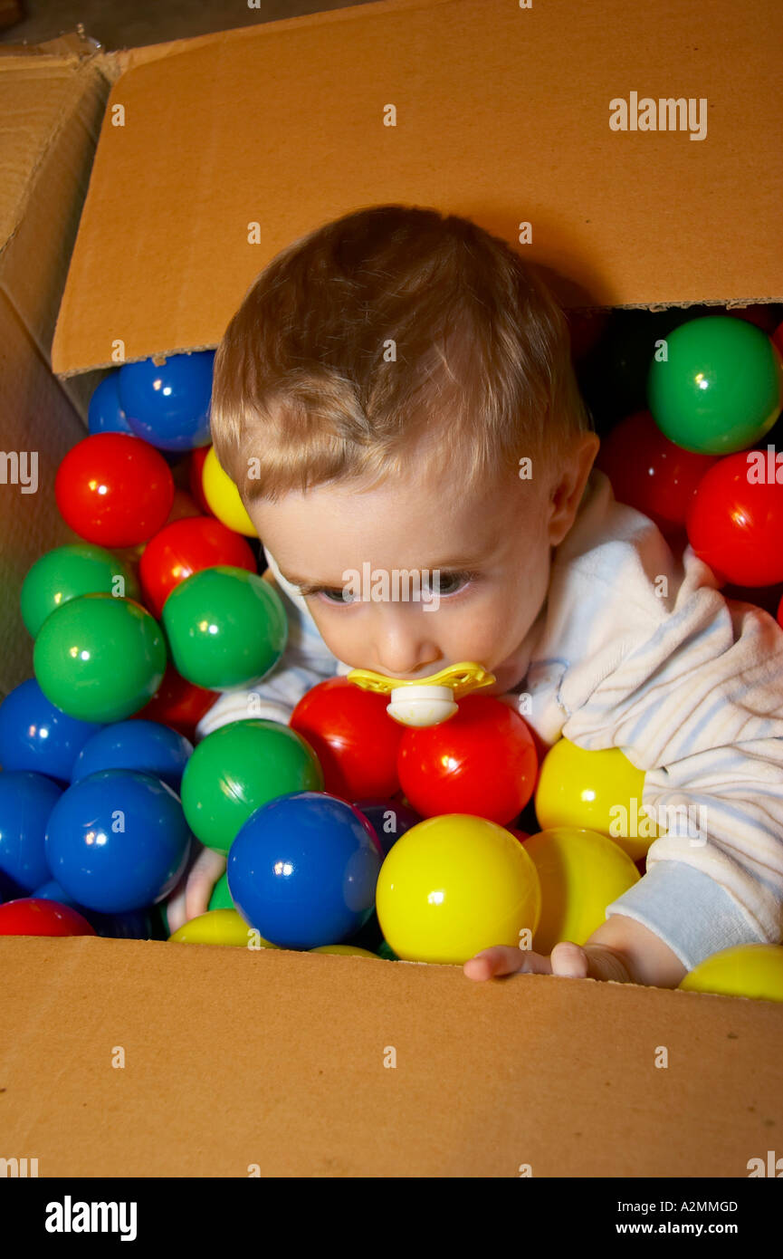 baby sitting in box with hundreds of colorful plastic balls Stock Photo ...