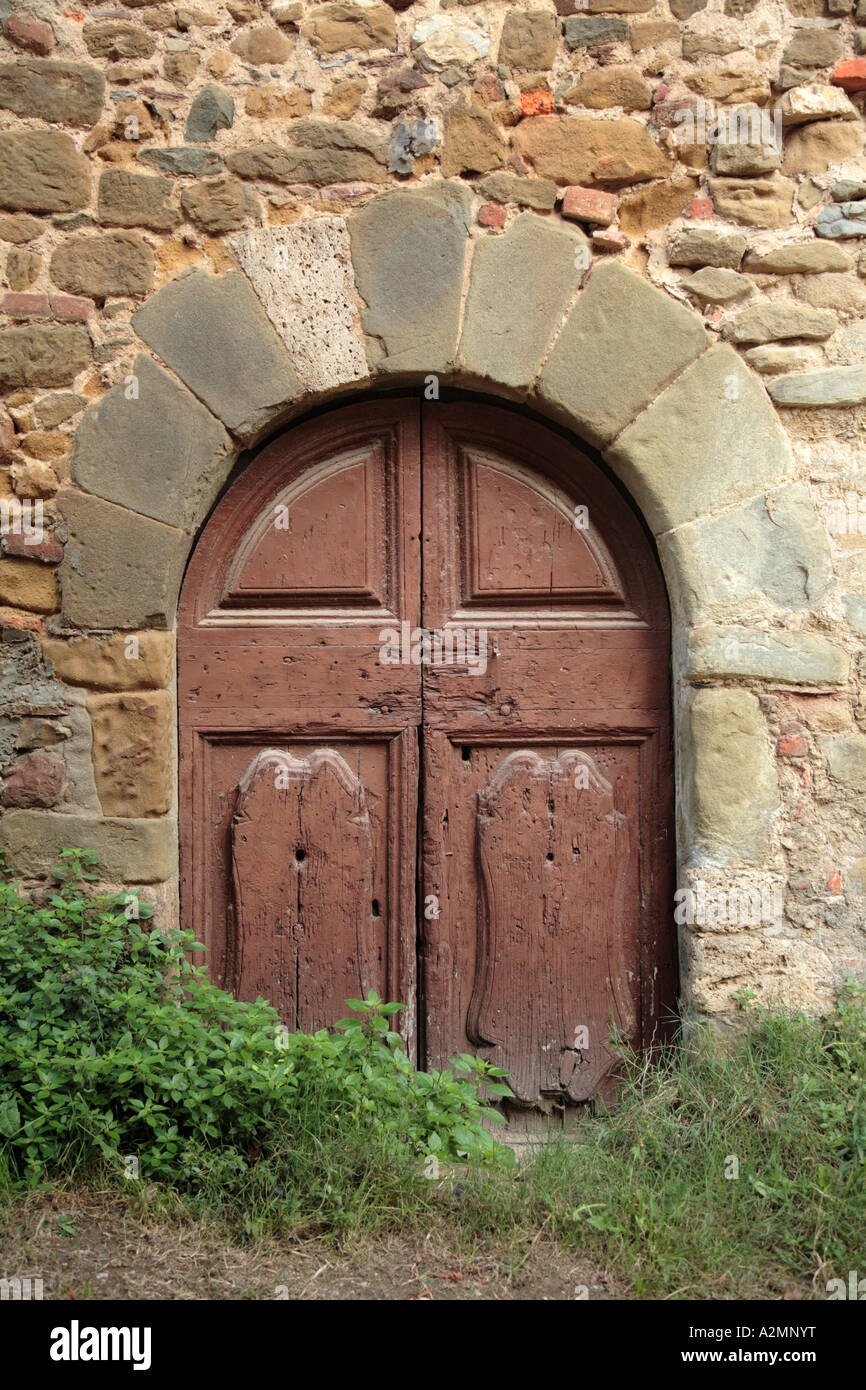 Small old arched stone entrance with wooden doors at the ancient ...