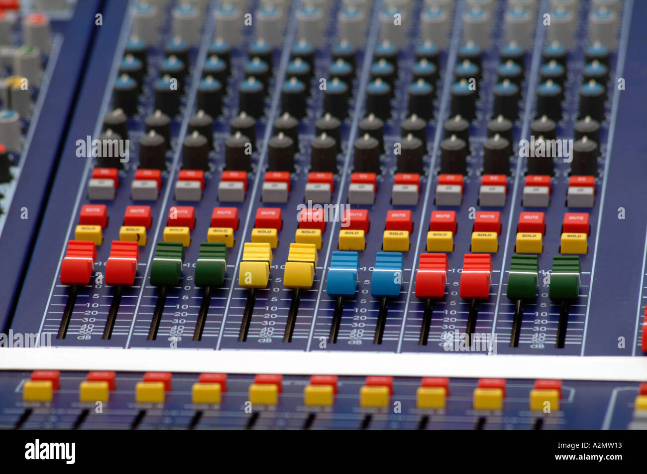 Closeup sound mixer audio console faders and equalisation controls in a ...