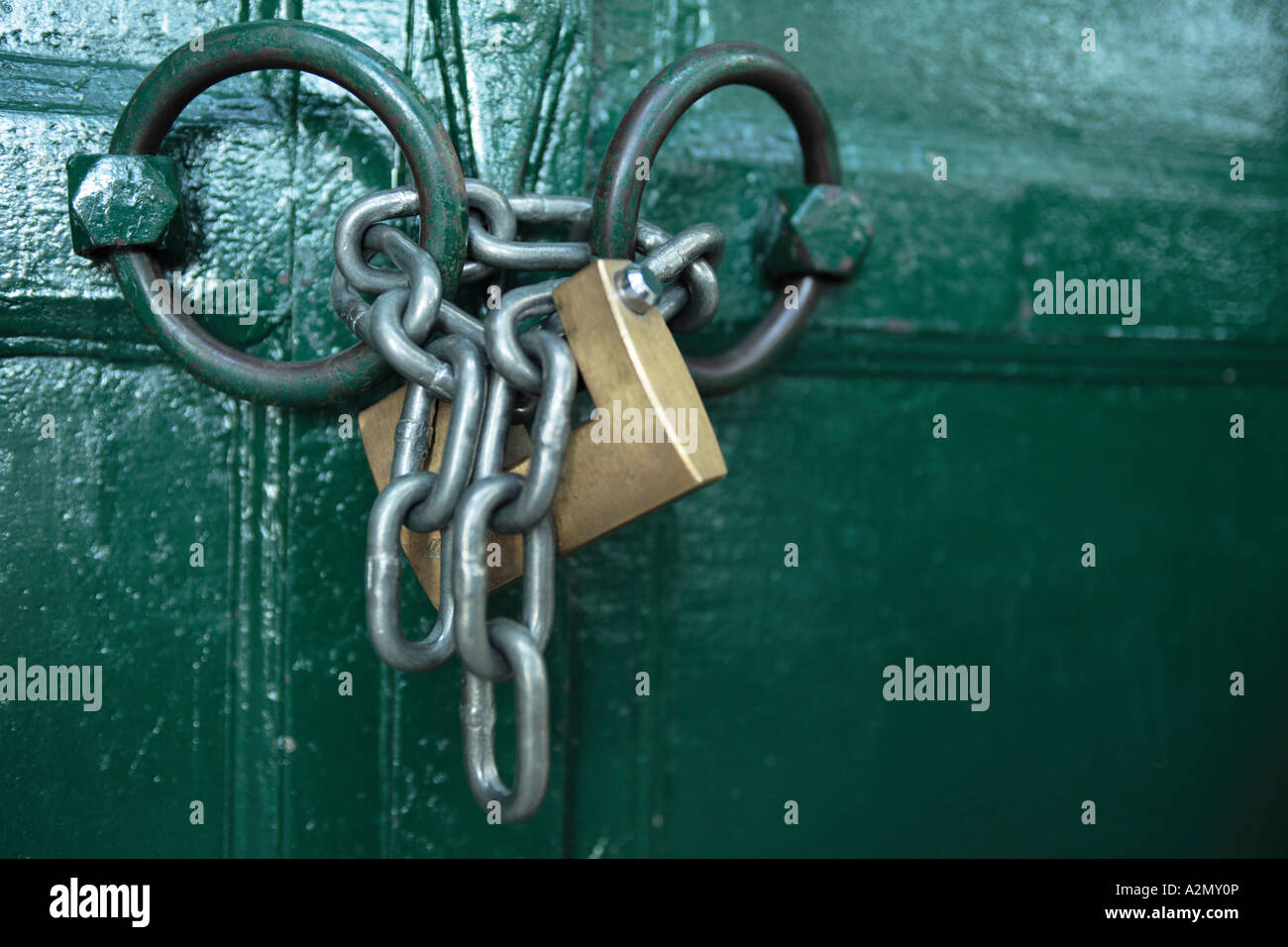 padlock, rings and chain on green painted timber door Stock Photo - Alamy