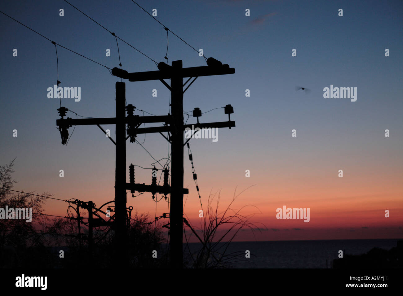 silhouette of power lines and pylon in greek resort Stock Photo - Alamy