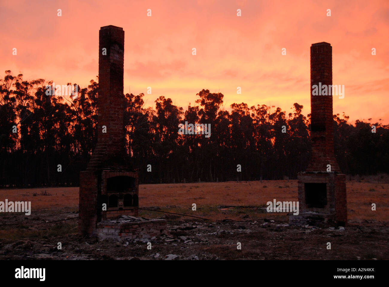 Twin chimney stacks against a sunset made richer by airborne particles ...
