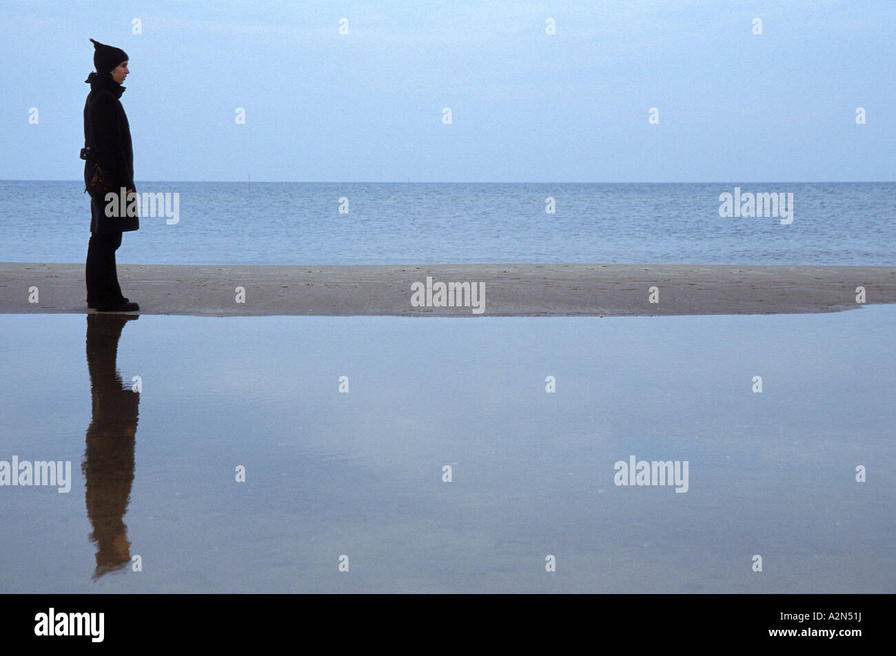 Side profile of woman standing on beach Stock Photo - Alamy