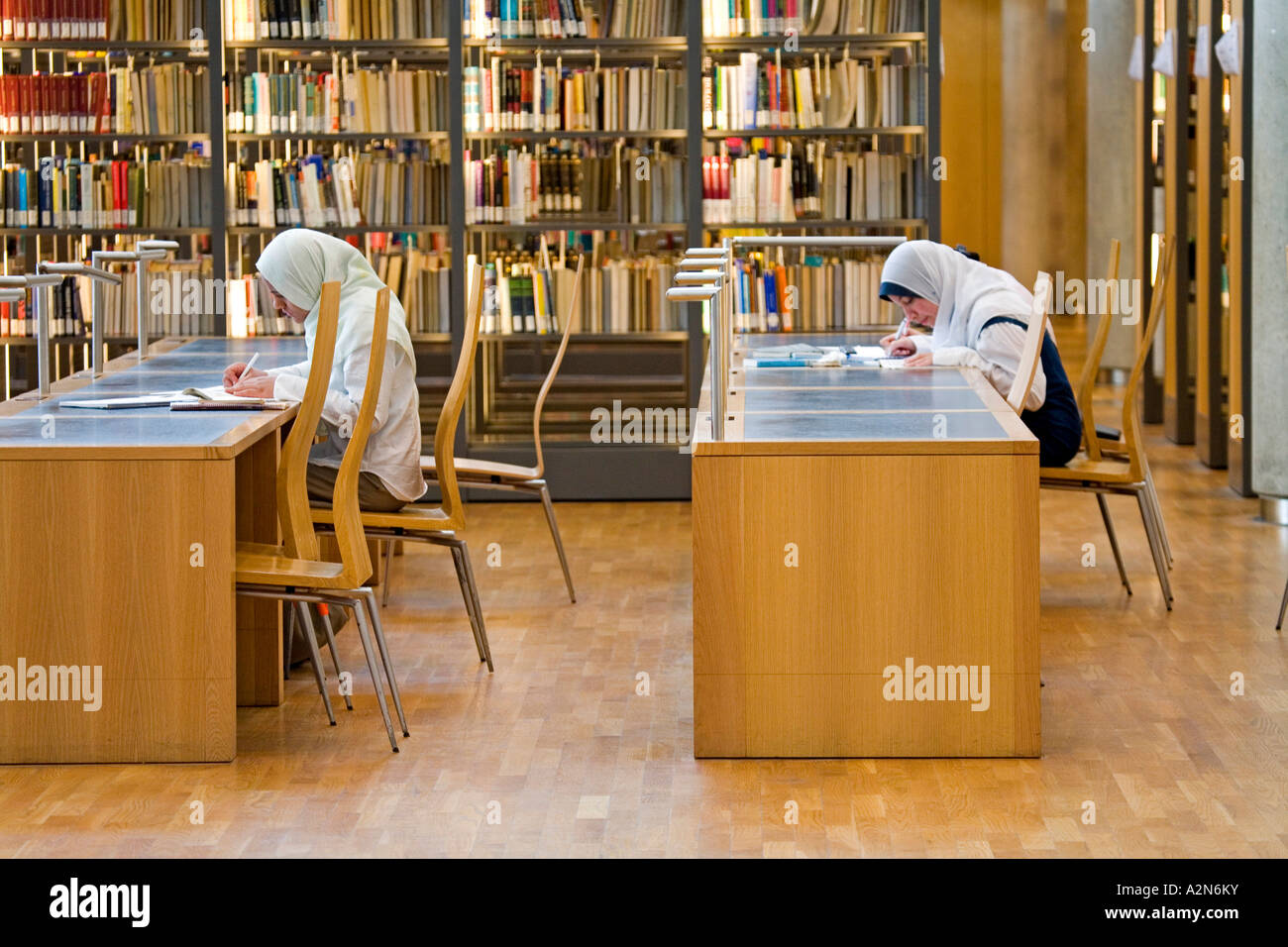 Two women sitting in library Stock Photo - Alamy