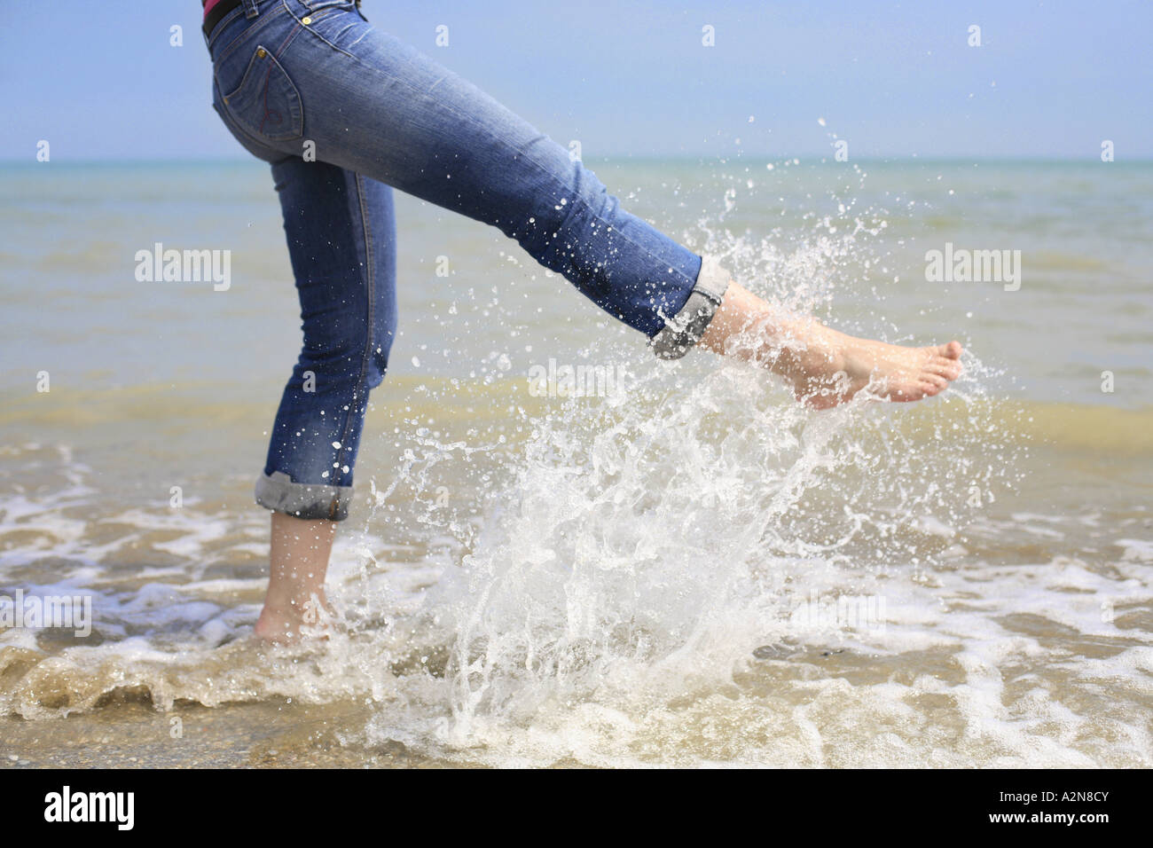 Low section view of woman splashing water Stock Photo - Alamy