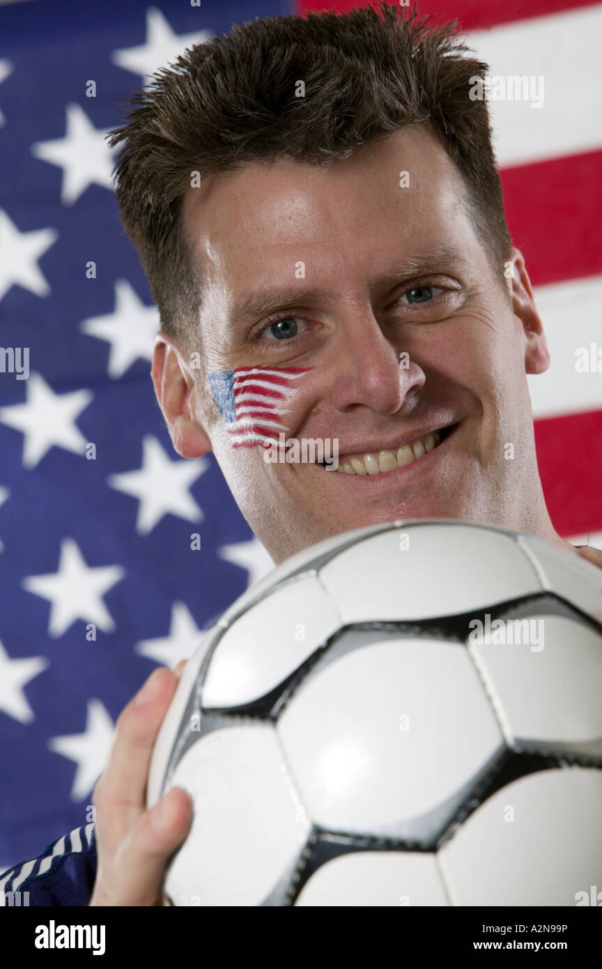 Portrait of male soccer fan holding soccer ball and smiling Stock Photo ...