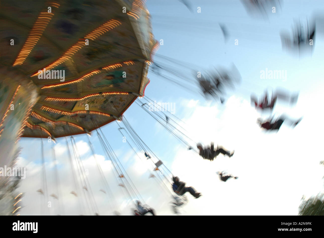 Low angle view of people riding on chain swing ride Stock Photo - Alamy