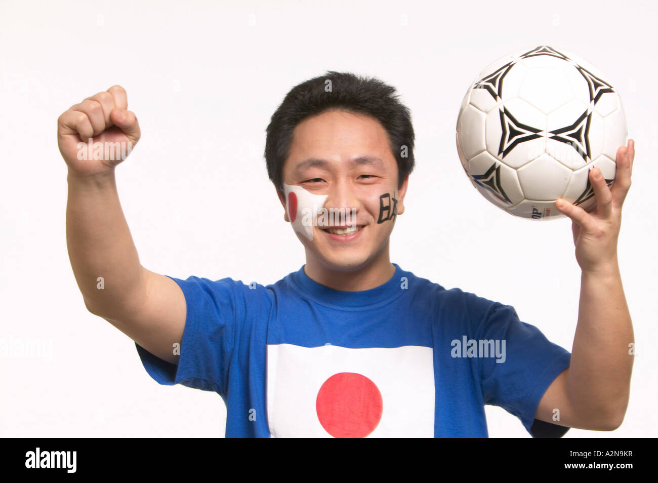 Portrait of male soccer fan holding soccer ball and smiling Stock Photo ...