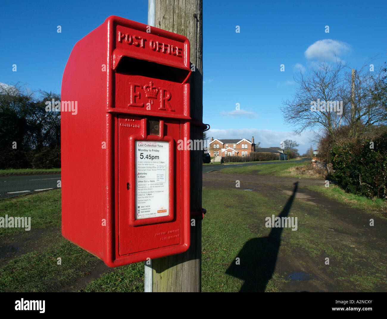 a bright red British post box fixed to a telegraph pole beside a ...