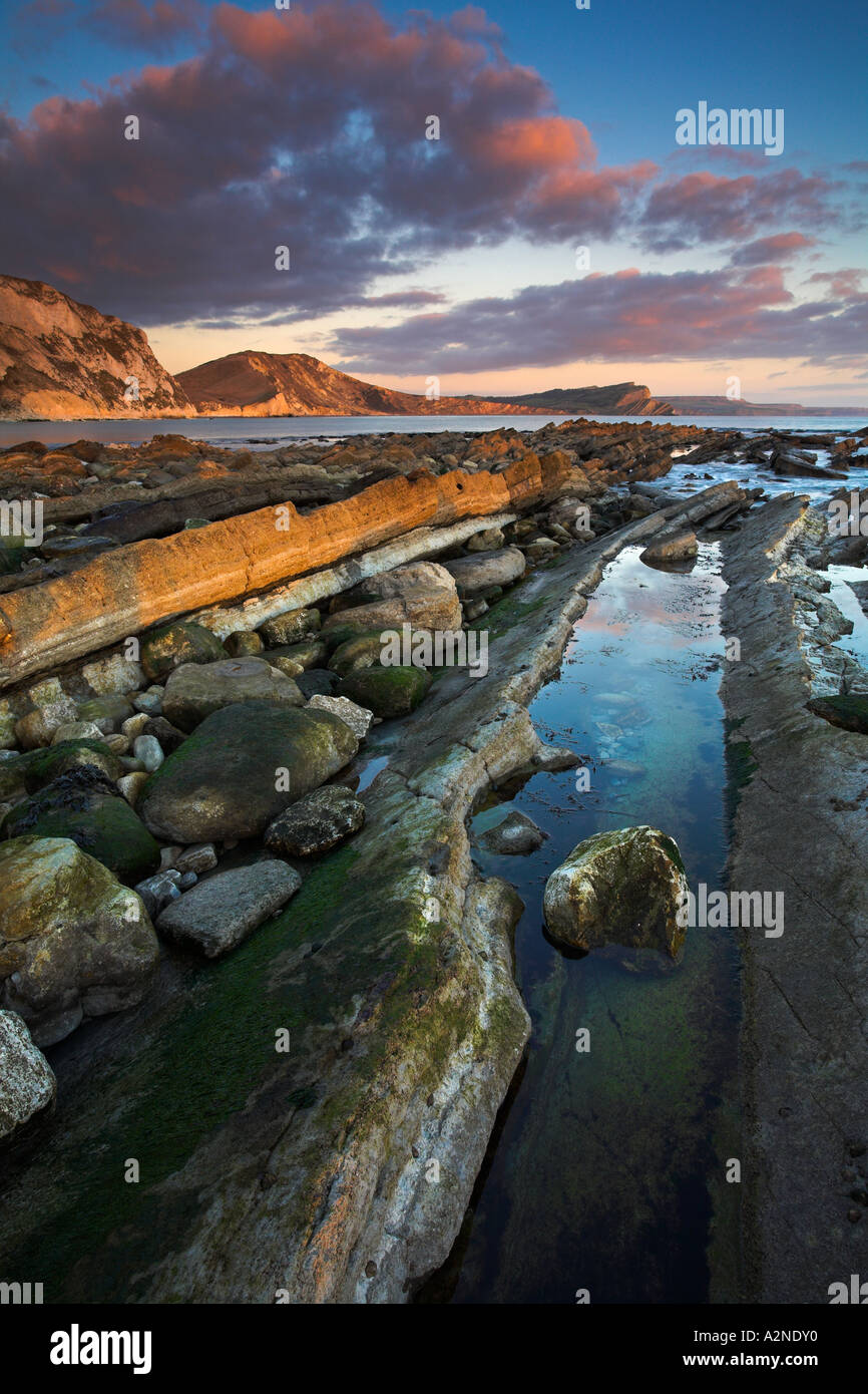 Late afternoon sunshine glows on the rocks and cliffs at Mupe Bay ...