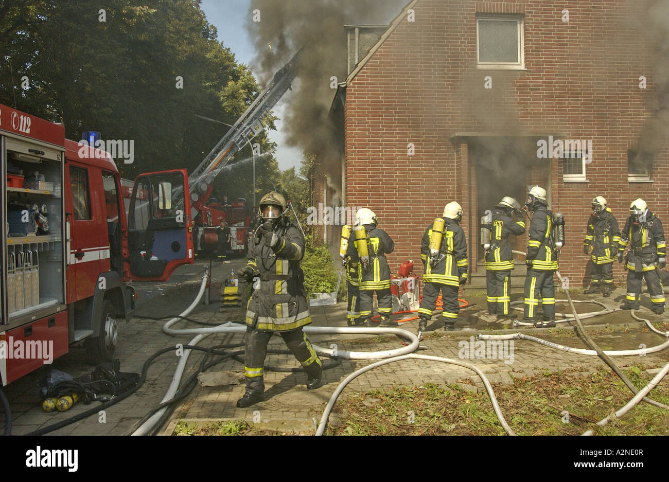 Firemen extinguishing fire in house Stock Photo - Alamy