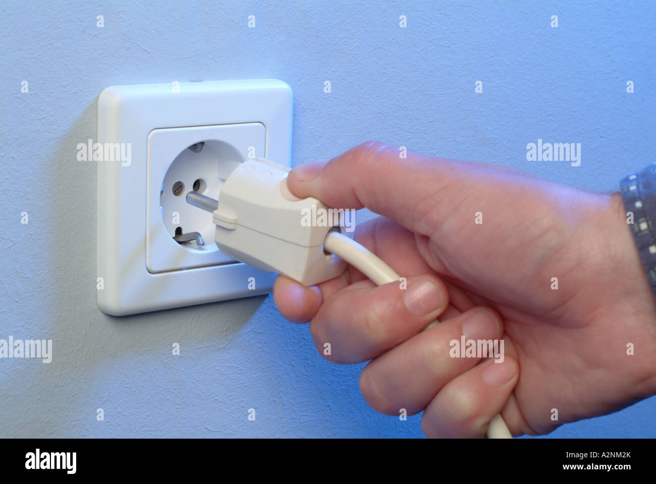 Person's hand inserting plug into socket Stock Photo - Alamy