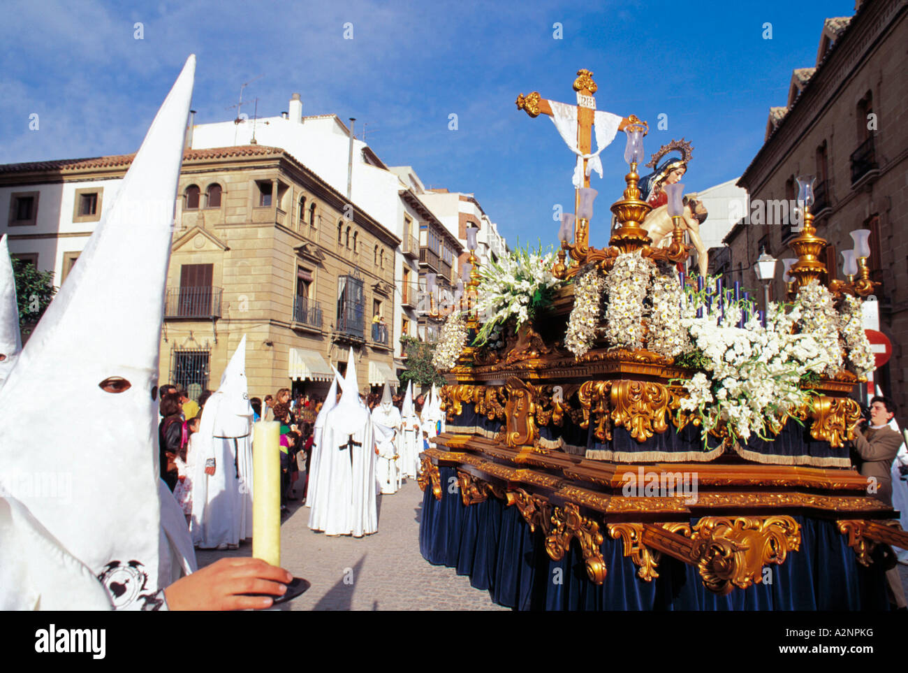 Hooded penitents around chariot in holy week procession, Andalusia ...