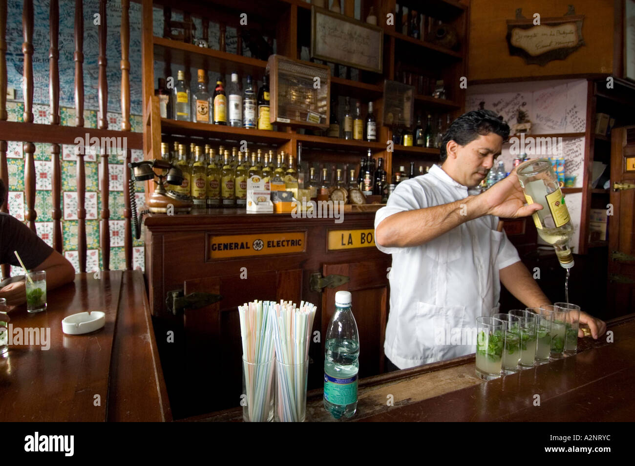 Barman pouring rum to make mojitos at La Bodeguita del Medio, Havana ...