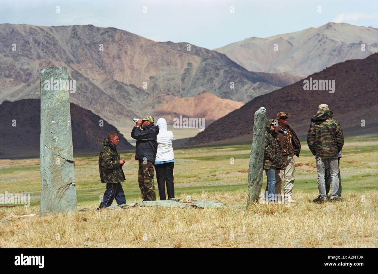Tourists watching ancient stone figurines. Barun Gol river’s valley ...