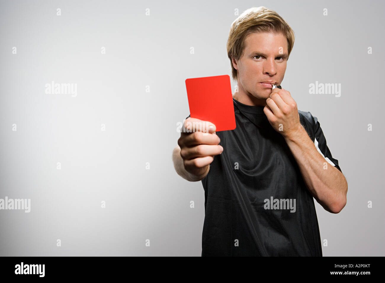 Referee holding red card and blowing whistle Stock Photo - Alamy
