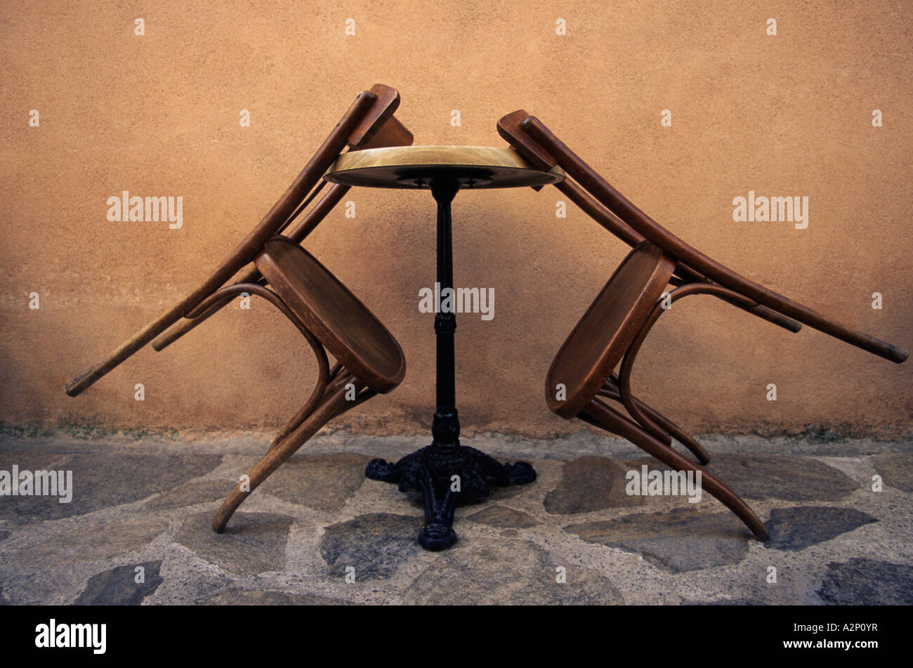 Wooden chairs leaning against table Stock Photo - Alamy