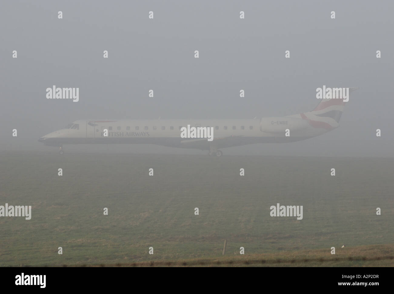 British Airways Embraer RJ145 aircraft taxiing in winter fog at ...