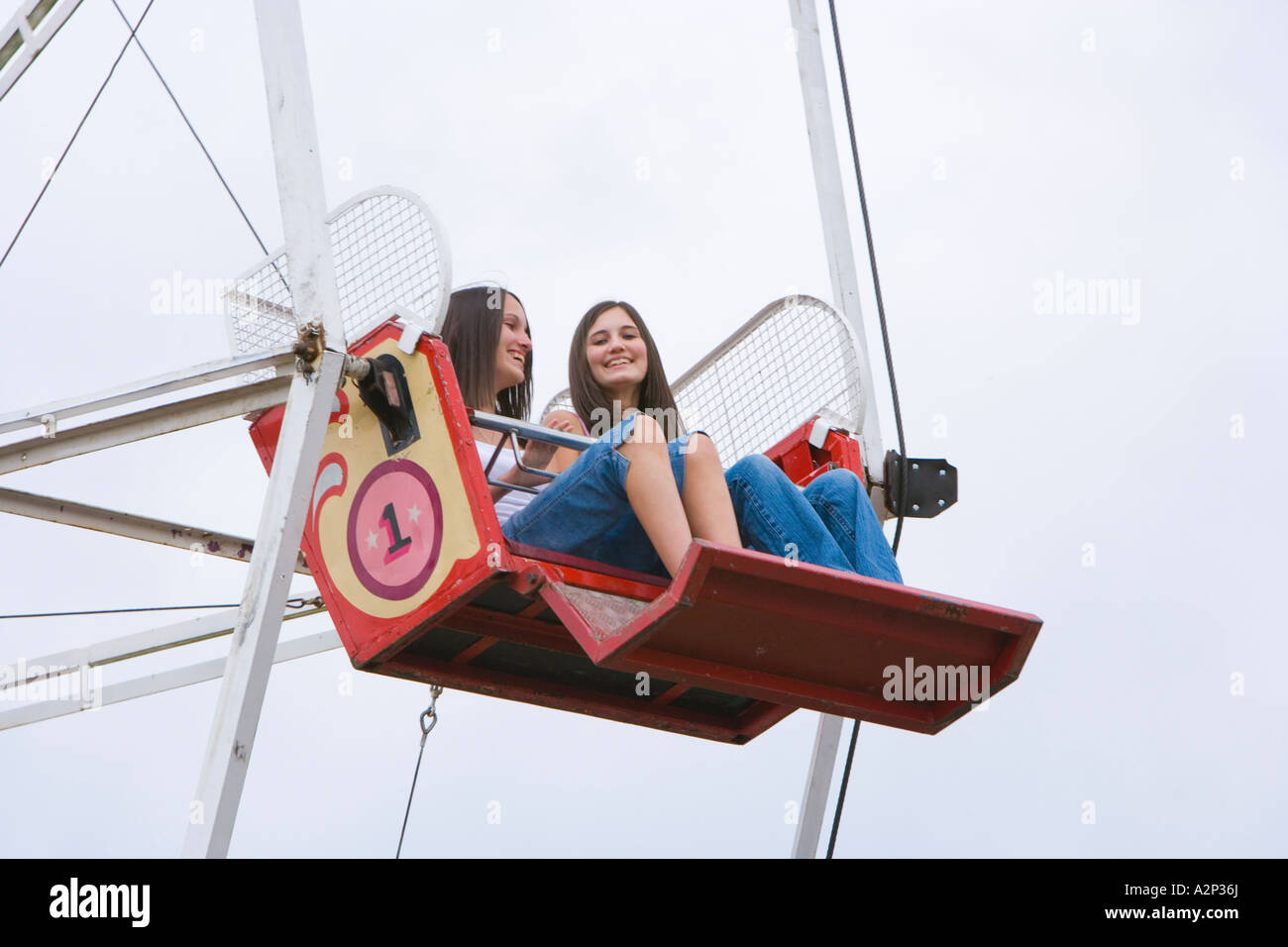 2 young girls enjoying a ride on a victorian fairground big wheel Stock ...