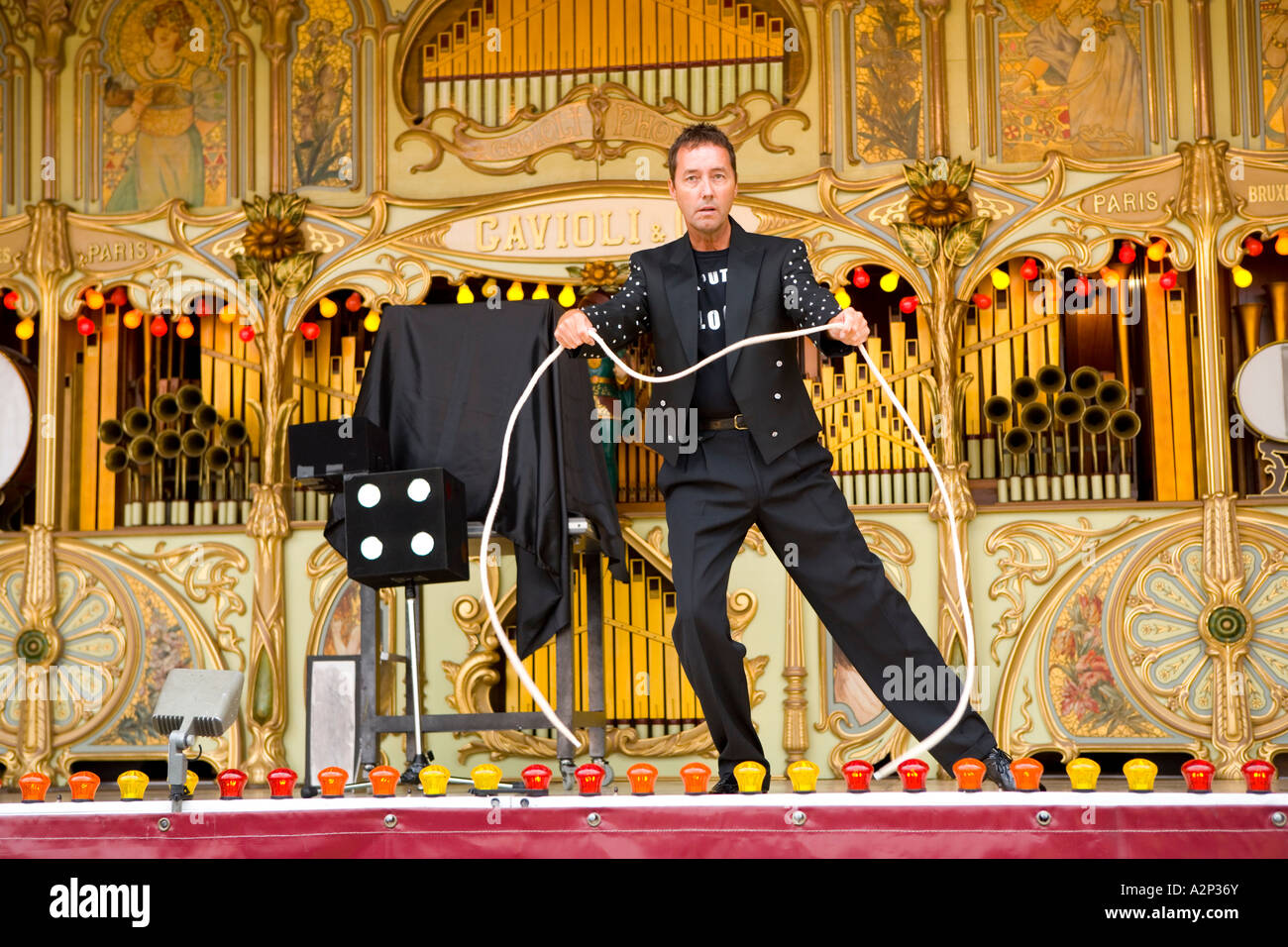 magician doing magic tricks on stage at a country fair with a pipe ...