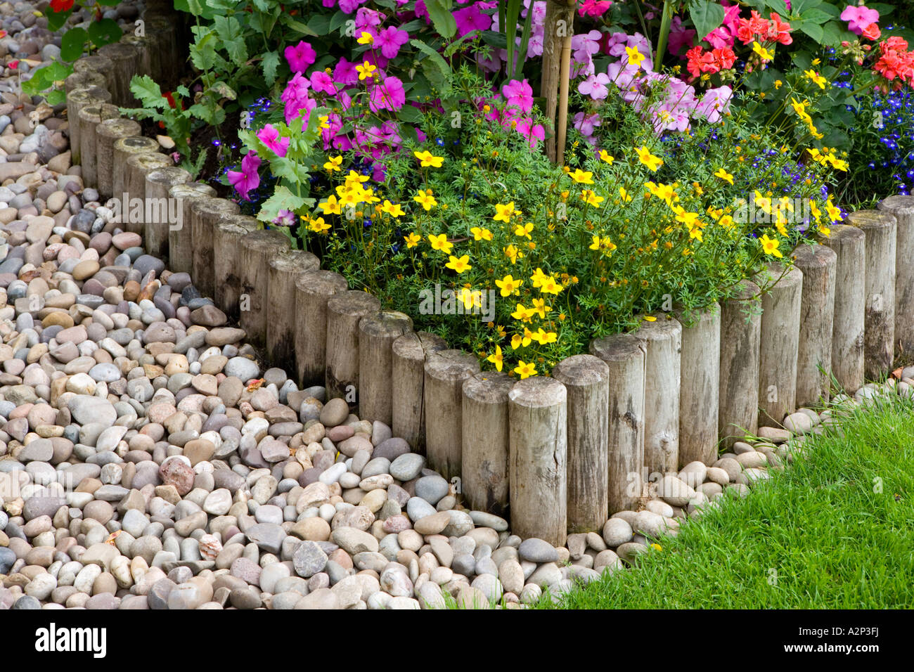 pebble path and flower bed edged by wooden posts Stock Photo - Alamy