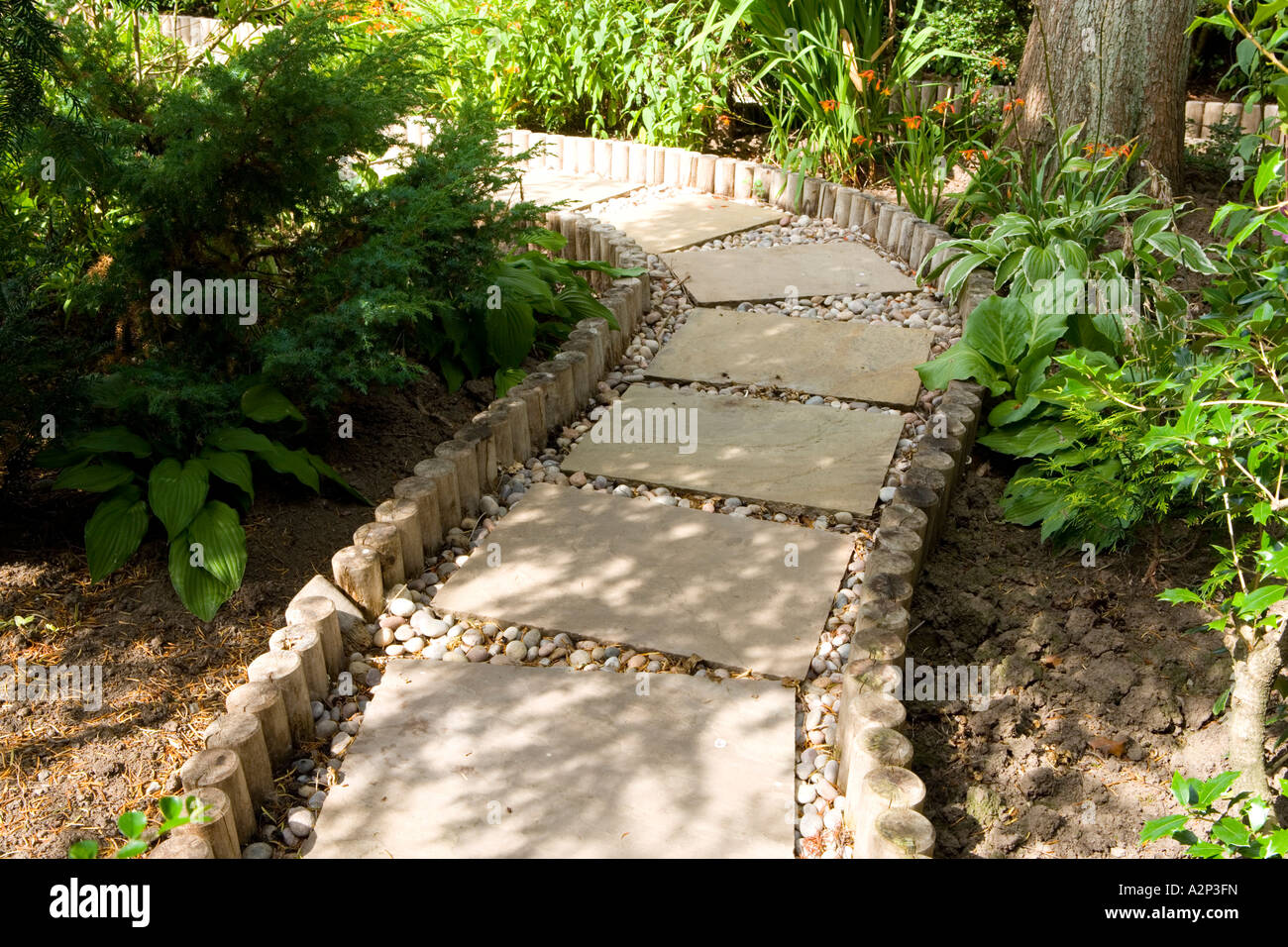 curved flagged path through a woodland garden Stock Photo - Alamy