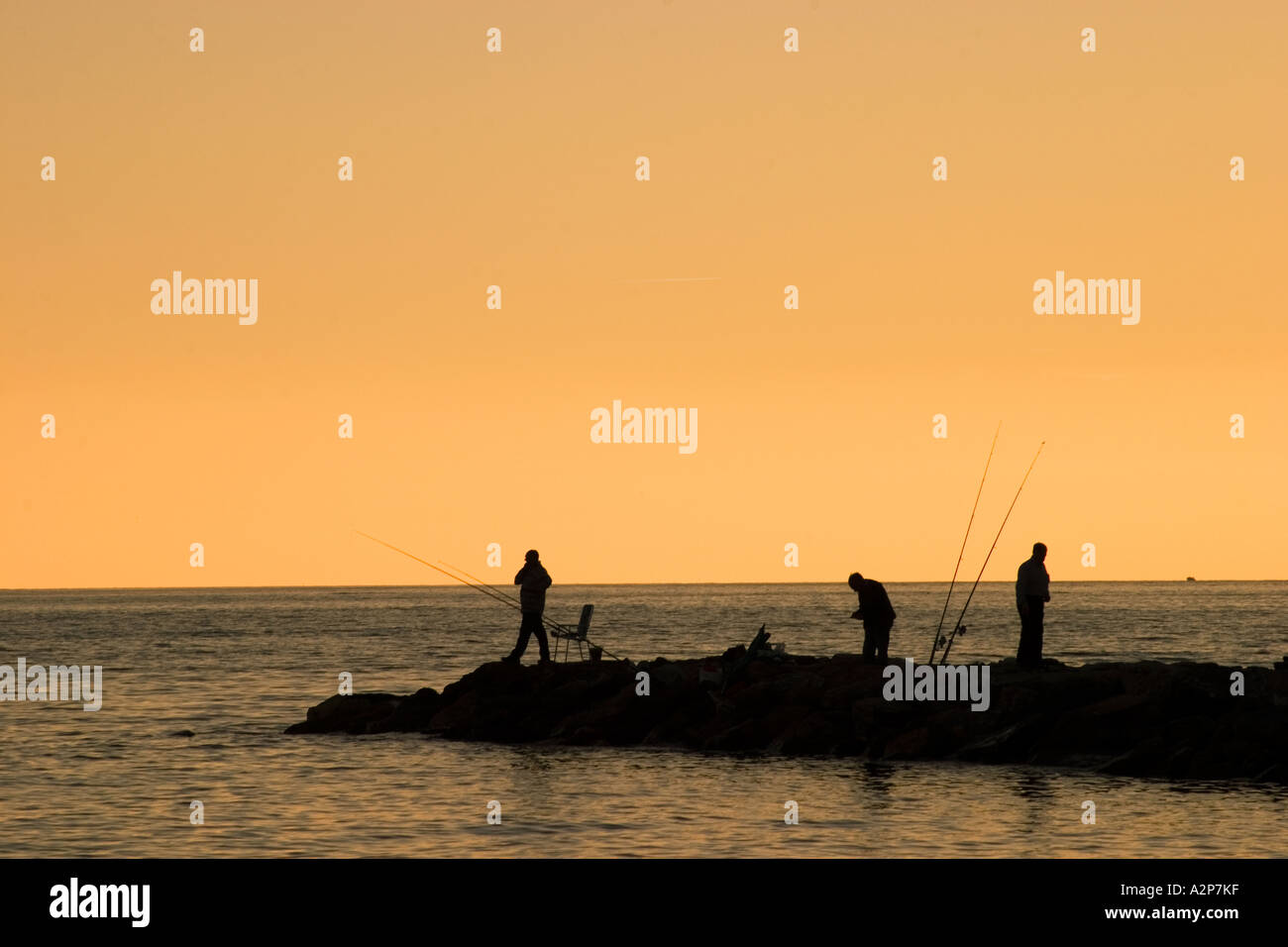Italian riviera sunset with fishers on the deck Stock Photo - Alamy