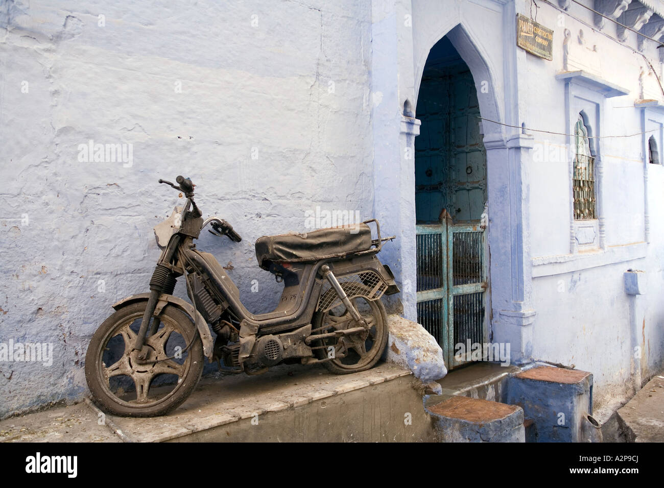 India Rajasthan Jodhpur old rusty moped in front of blue painted house ...