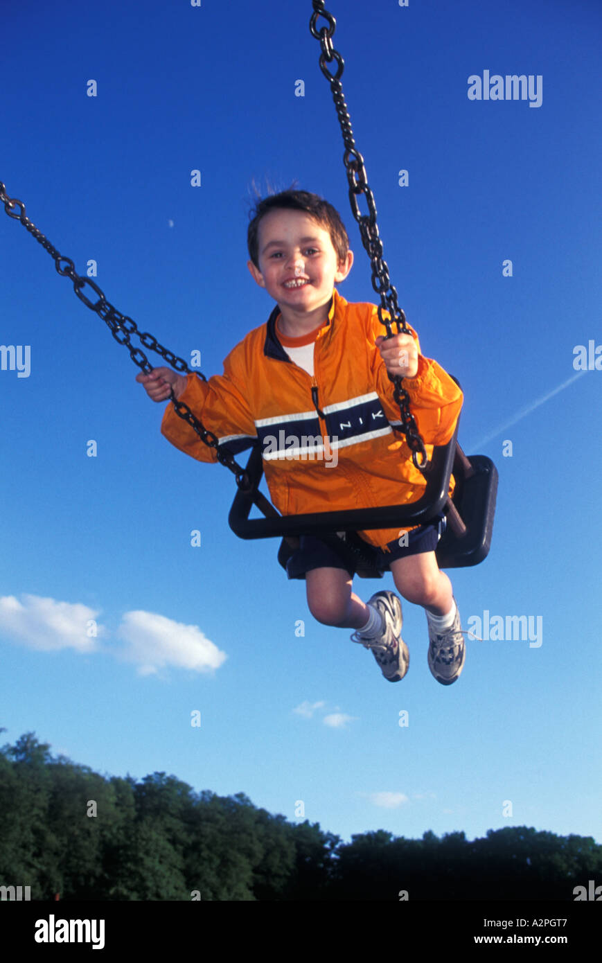 Young boy on swing Stock Photo - Alamy