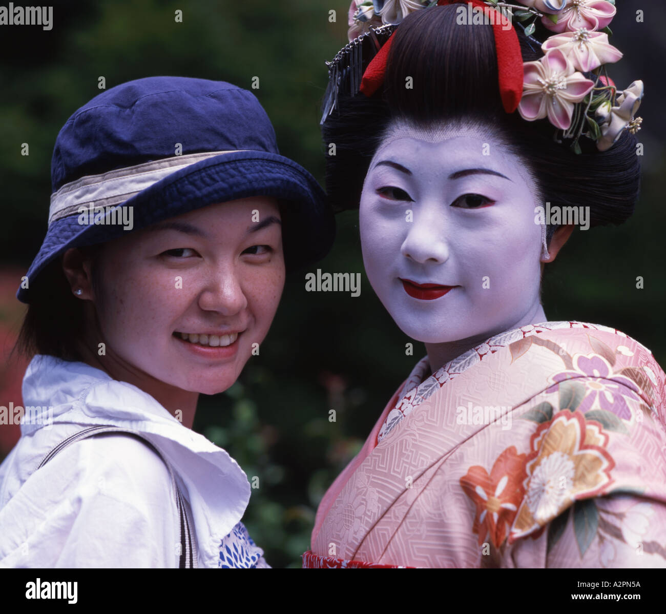 Tourist poses with girl in maiko trainee Geisha costume in Japanese ...