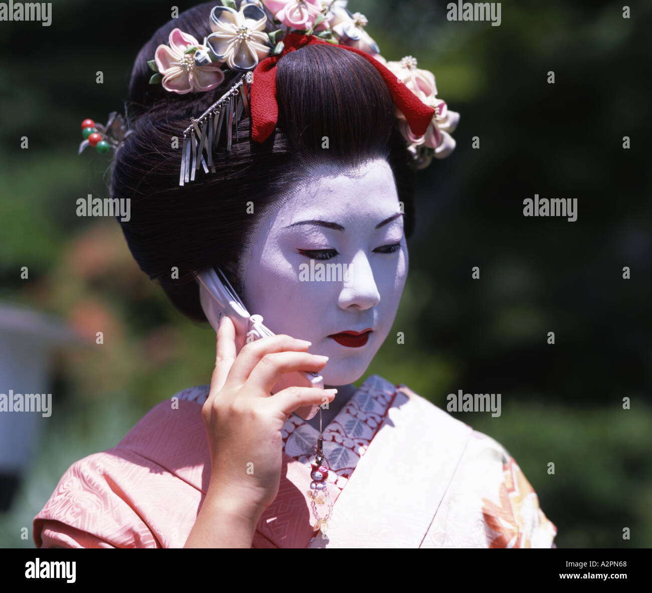 Girl in maiko trainee Geisha costume uses her cell phone Gion Kyoto ...