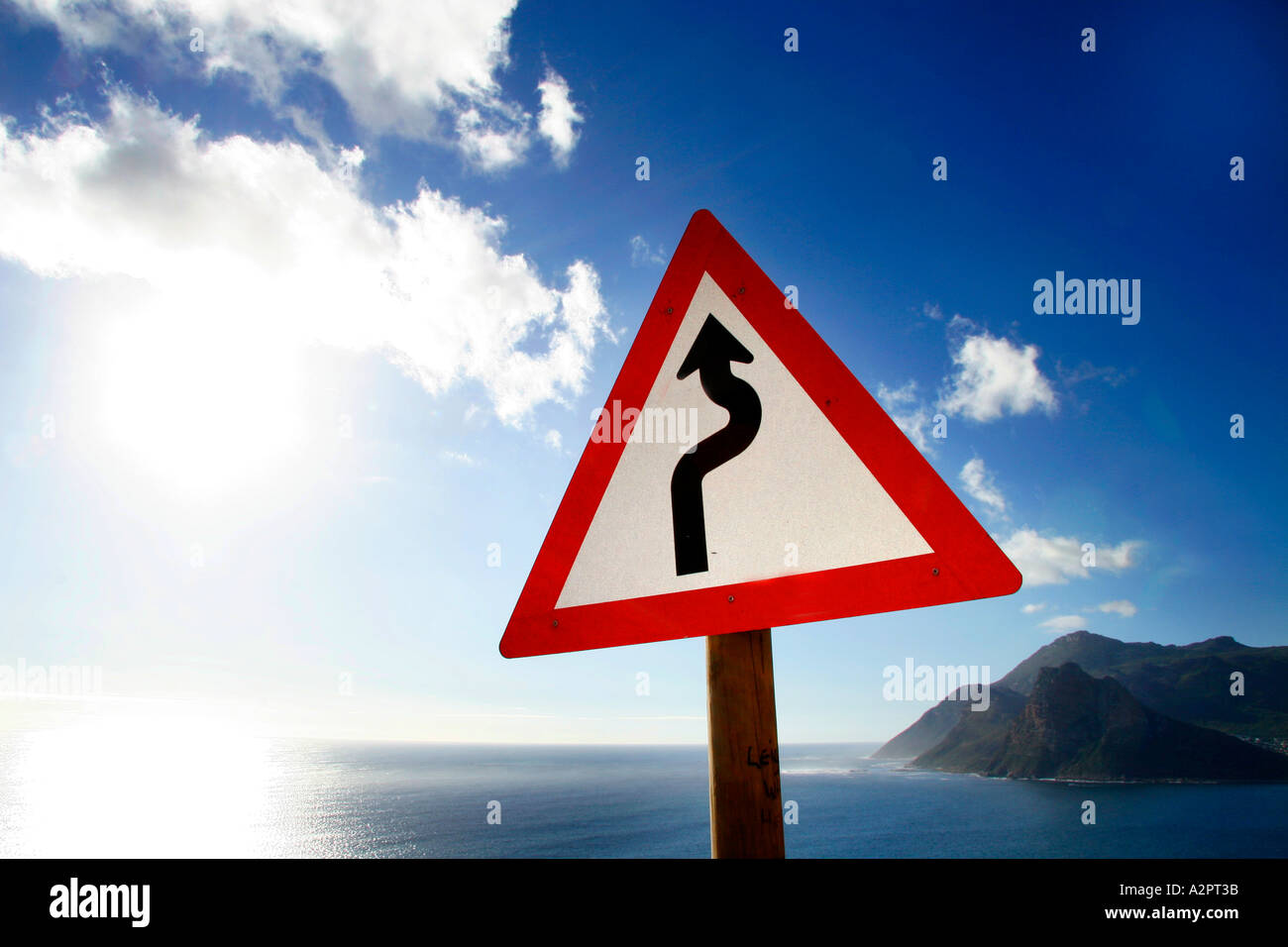 Caution windy road ahead road sign hazard Stock Photo - Alamy