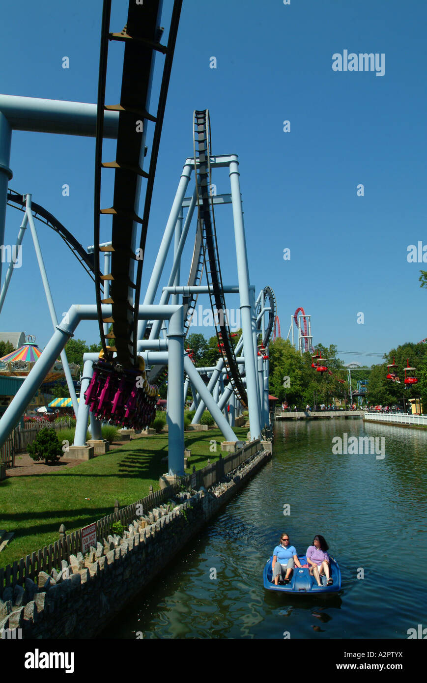Paddle boats on a waterway between two roller coasters Stock Photo - Alamy