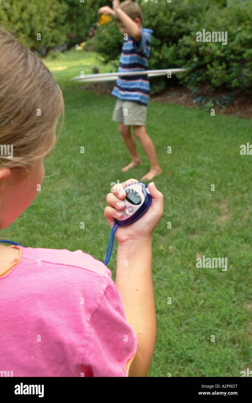 10 year old girl uses a digital stop watch to time her 7 year old ...