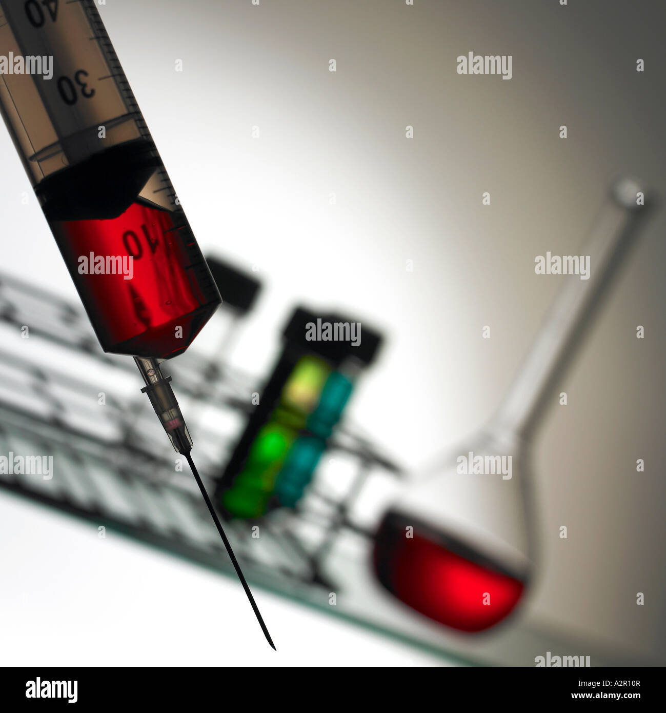 Syringe with Shelf in Background with Glassware Stock Photo - Alamy