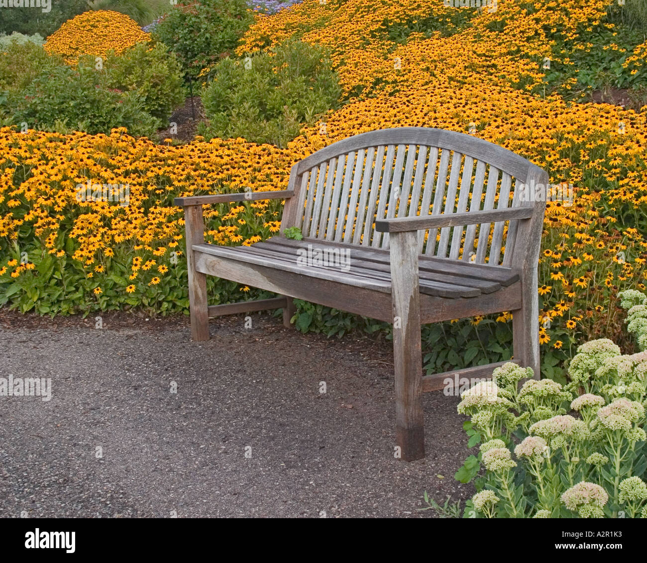 Bench surrounded by flowers Stock Photo - Alamy