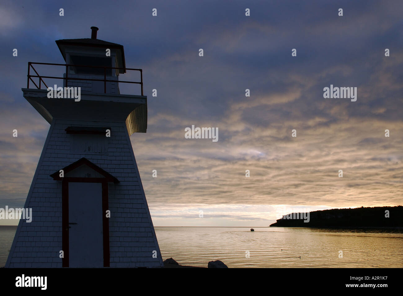 Lighthouse with fishing boat at dawn at Lions Head on lake Huron ...