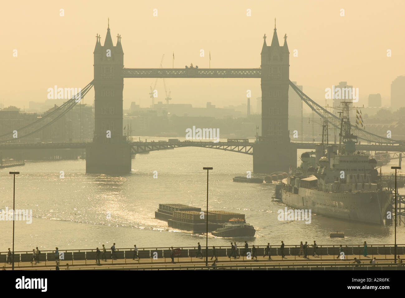 pedestrians crossing london bridge over the river thames in front of ...