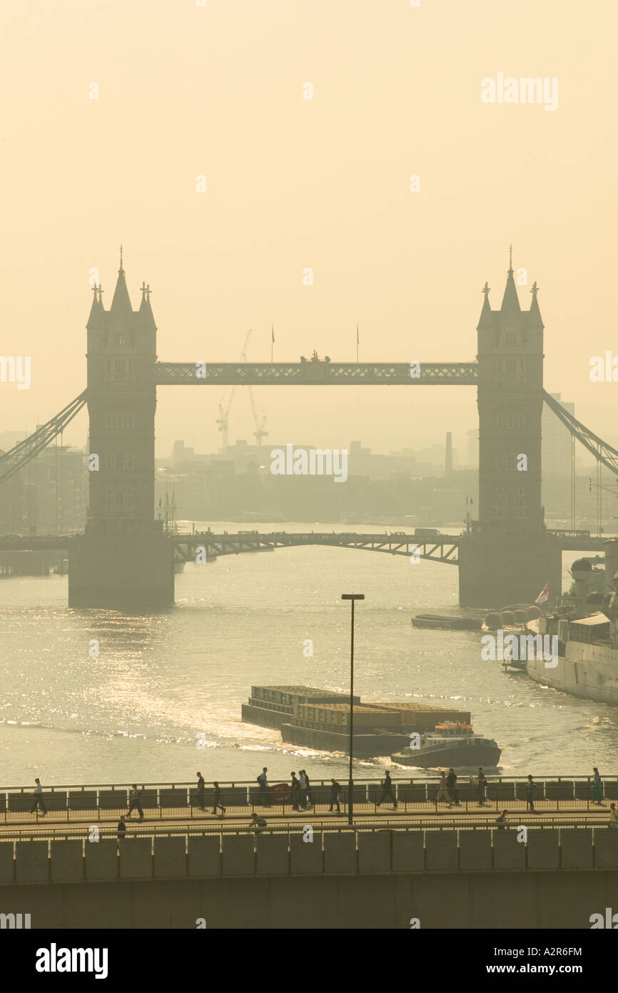 pedestrians crossing london bridge over the river thames in front of ...