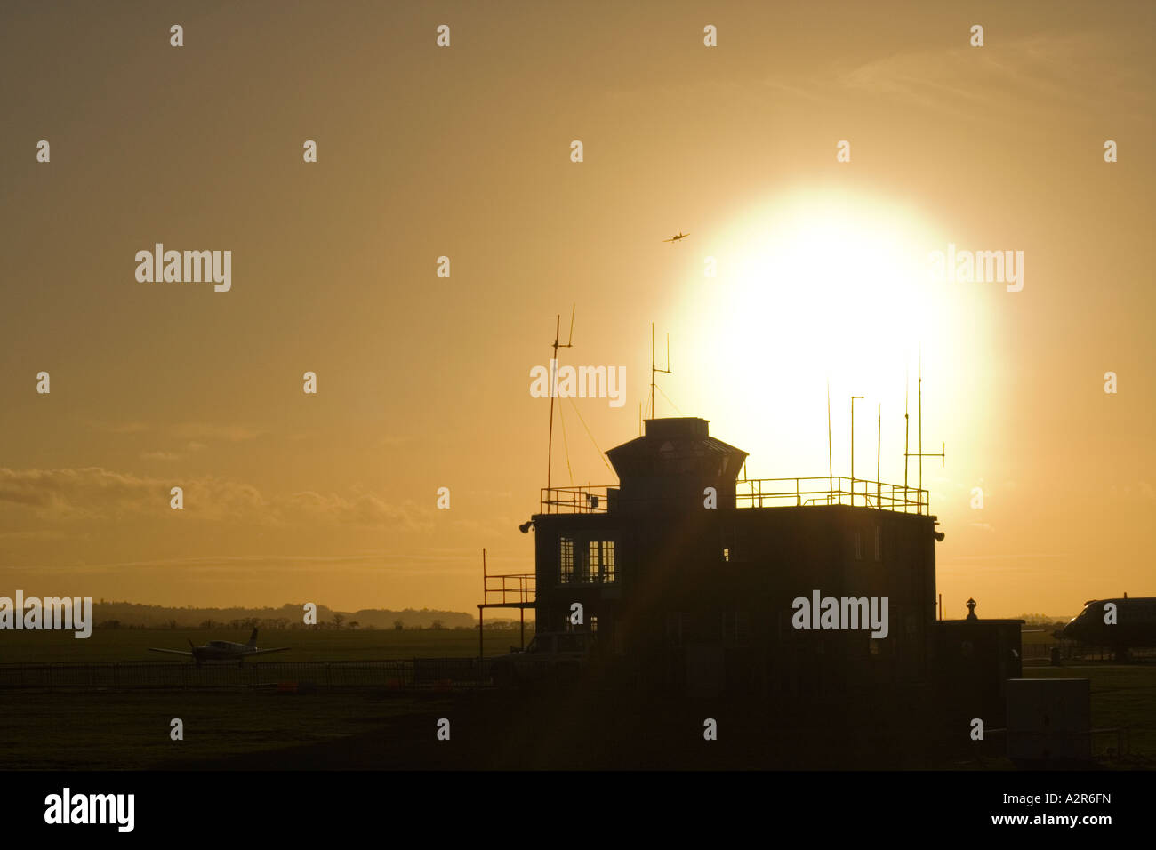 sun setting behind control tower at Duxford air museum as plane lands ...