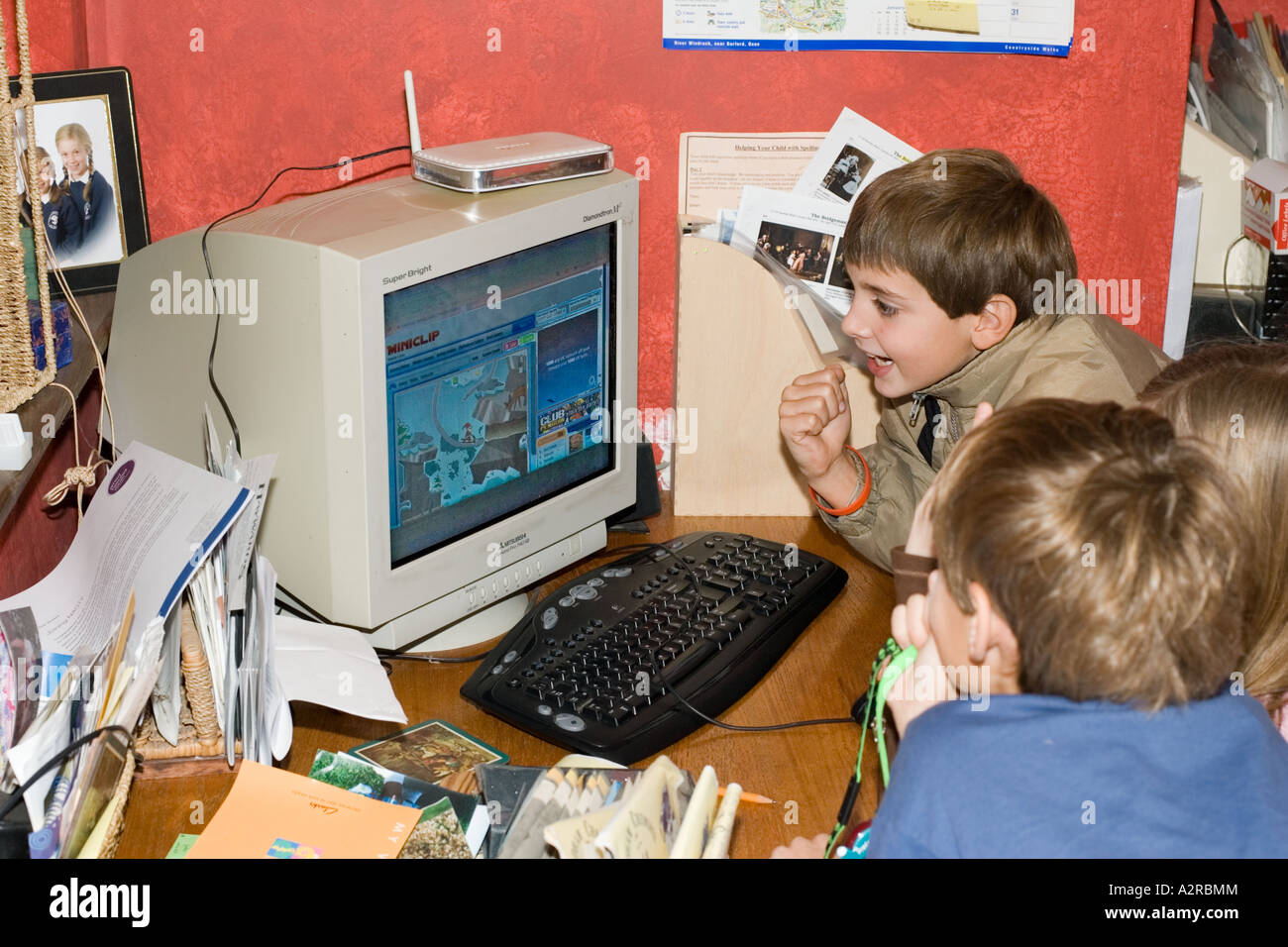 Three young children around monitor playing computer games UK Stock ...