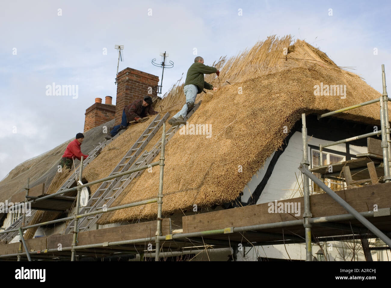 Rural craftsmen on roof thatching cottage near Stratford UK Stock Photo ...